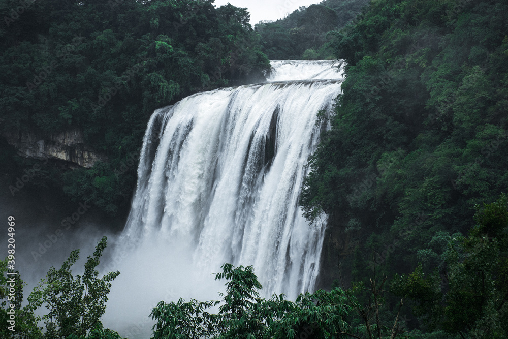The waterfall interrupts violently the peaceful continuous flow of the ...