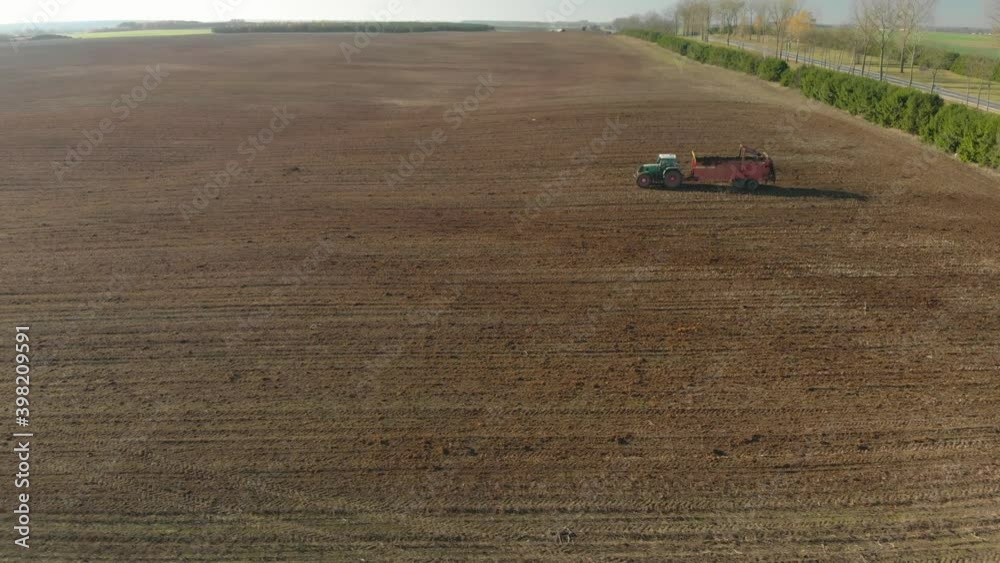 Tractor with an organic and mineral fertilizer spreader distributes ...