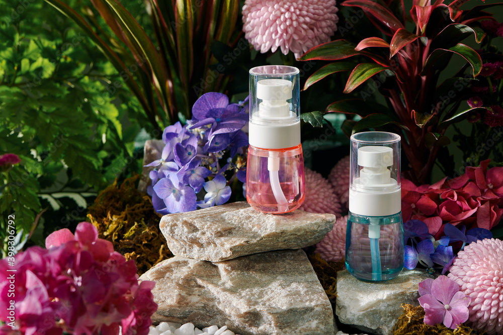 Essential oil bottles with flowers and green freshness. Herbal beauty ...