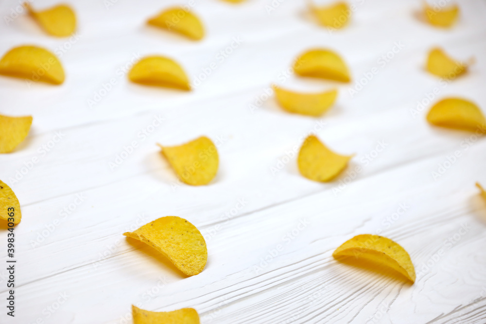 Many orange Pringles potato snack chips on white wooden table. Pringles ...