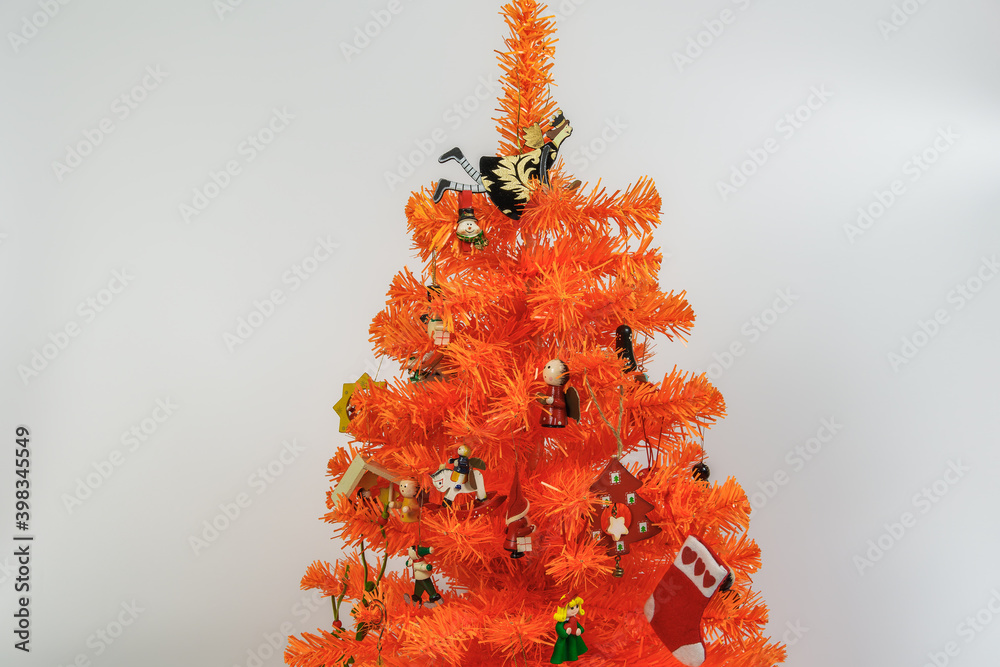 Artificial orange Christmas tree with ornaments against white ...