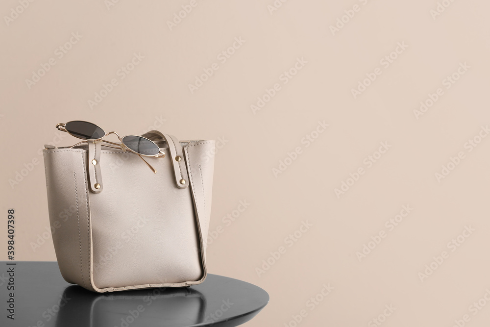 Stylish bag on table against color background Stock Photo | Adobe Stock
