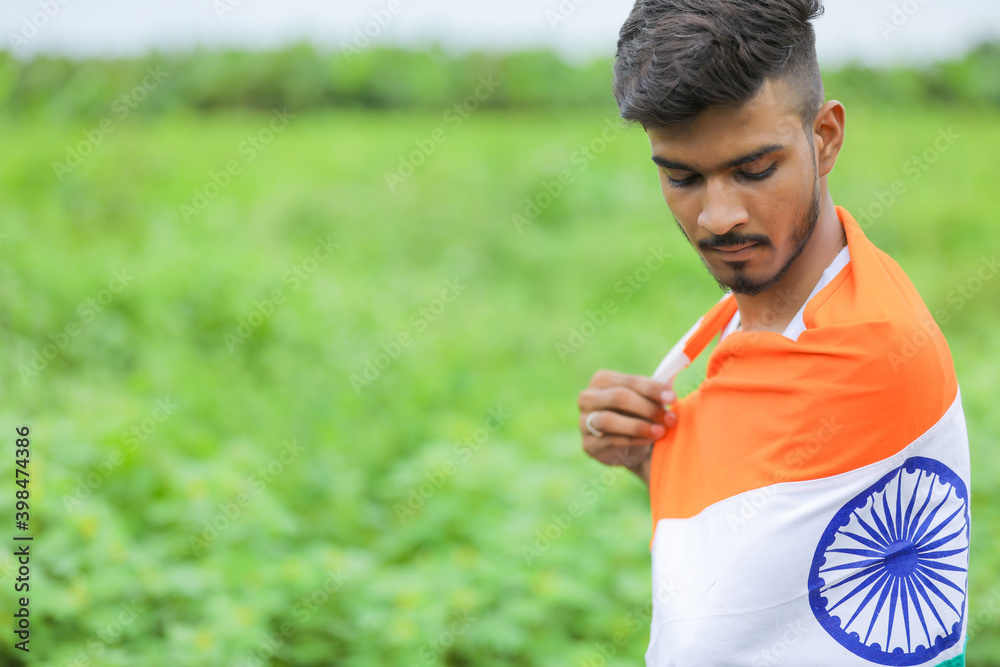 Young indian man waving indian national flag over nature background ...