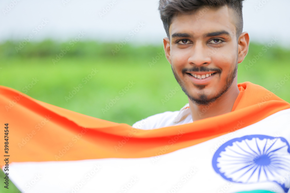 Young indian man waving indian national flag over nature background ...