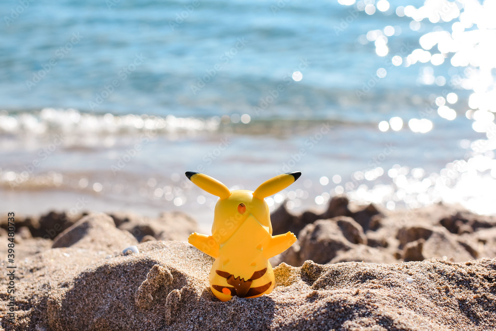 Pikachu figure model sitting on a sandy beach by the sea. Stock Photo ...