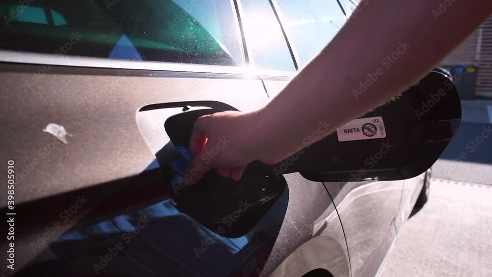 Refuelling the car with diesel fuel. A hand inserts a pistol into the ...