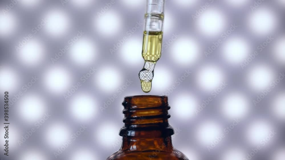 A pipette / dropper dispensing a drop of solution / medicine / vitamin ...