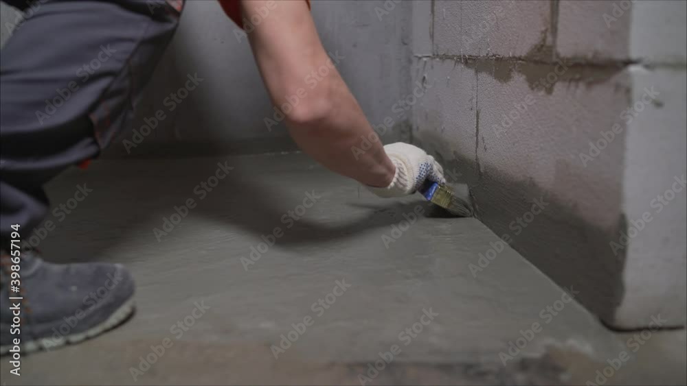 Waterproofing the floor with a mixture. Hand mixes waterproofing mortar ...