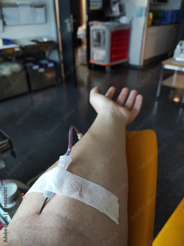 Arm with a line drawing blood. Altruistic blood donation. POV of a ...
