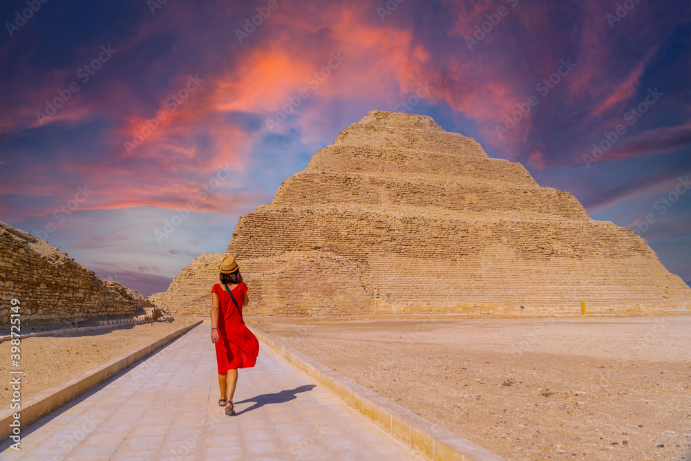 A young tourist in a red dress at the Stepped Pyramid of Djoser at ...