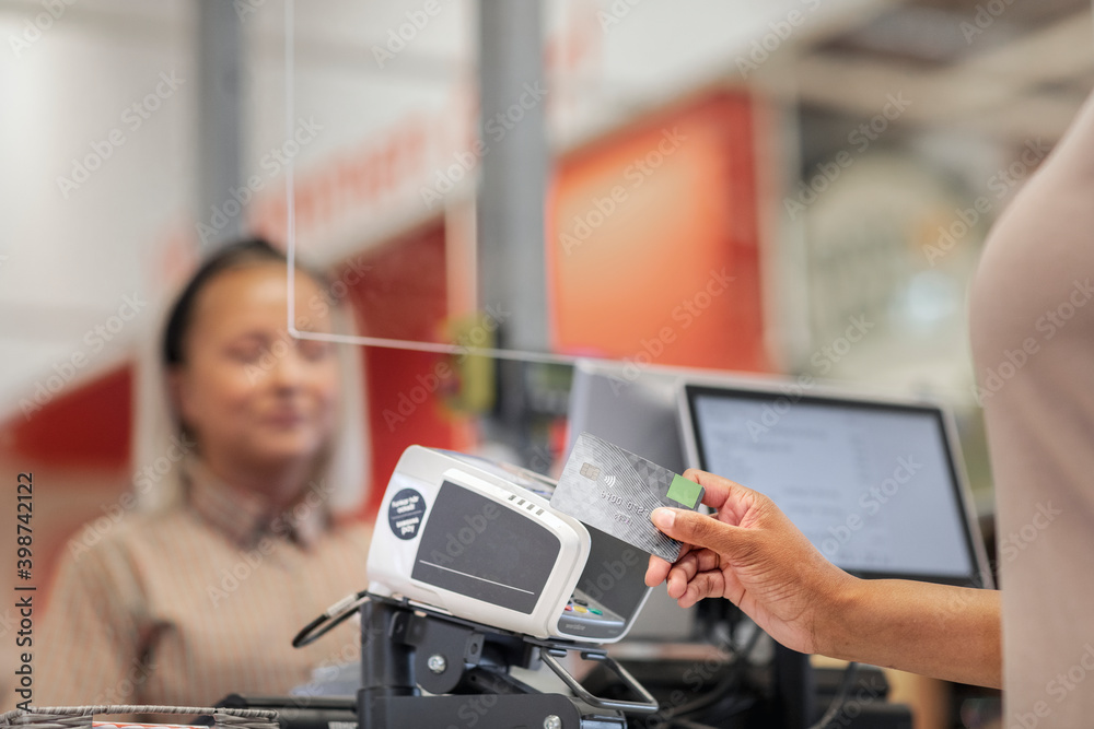 Hand with credit card paying at till Stock Photo | Adobe Stock
