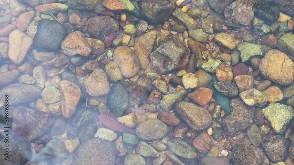 The rippling water of the submerged rocky river looks fresh and ...