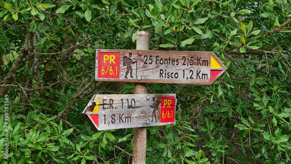 Wooden signpost with red and yellow colored markings pointing the way ...