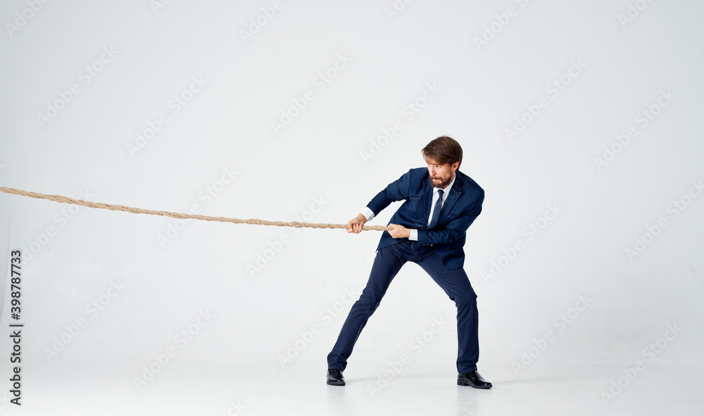 business man with a rope in his hands on a light background tension ...