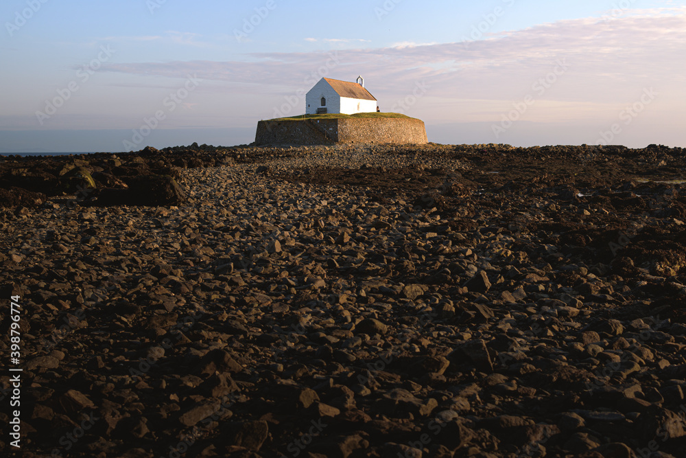 Eglwys Cwyfan, St. Cwyfan's Church. A medieval, small, white church on ...