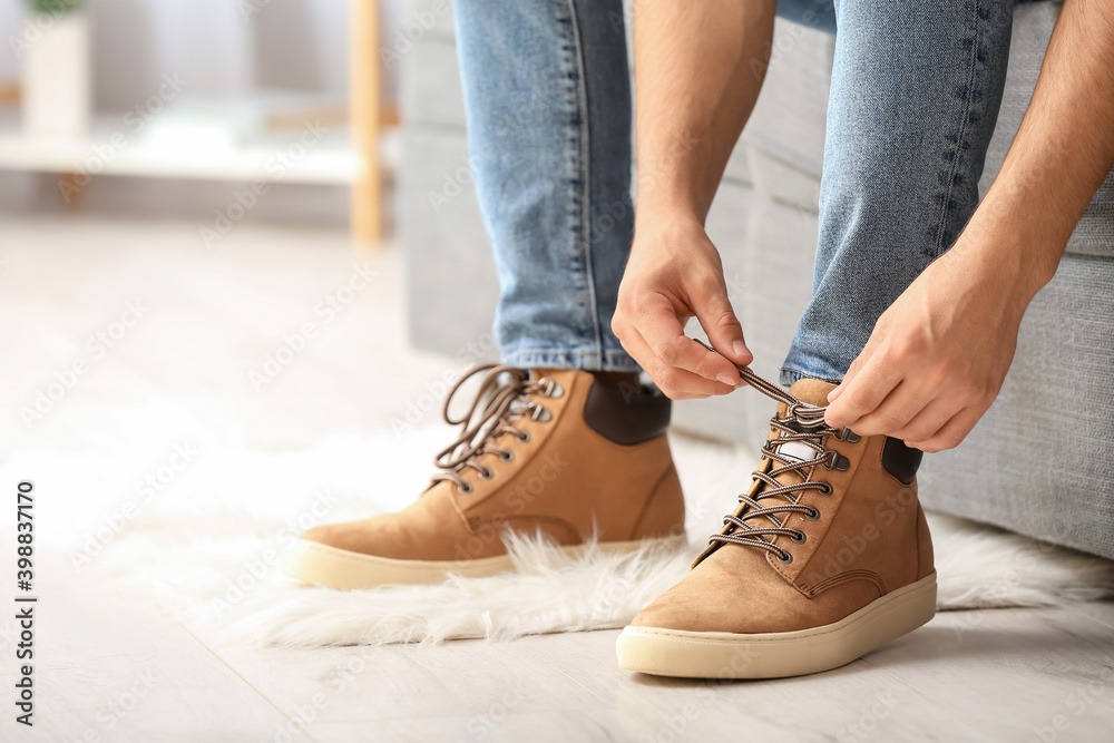 Young man putting on stylish shoes Stock-Foto | Adobe Stock