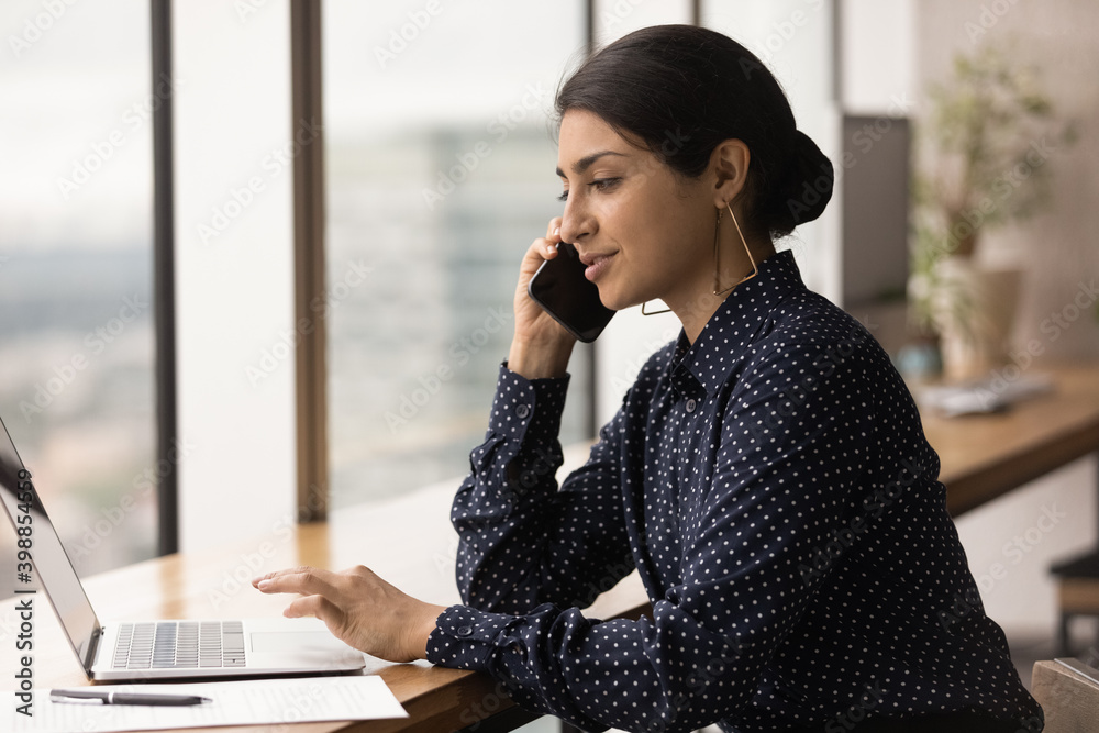 Young ethnic woman look at laptop screen working online, talk on ...
