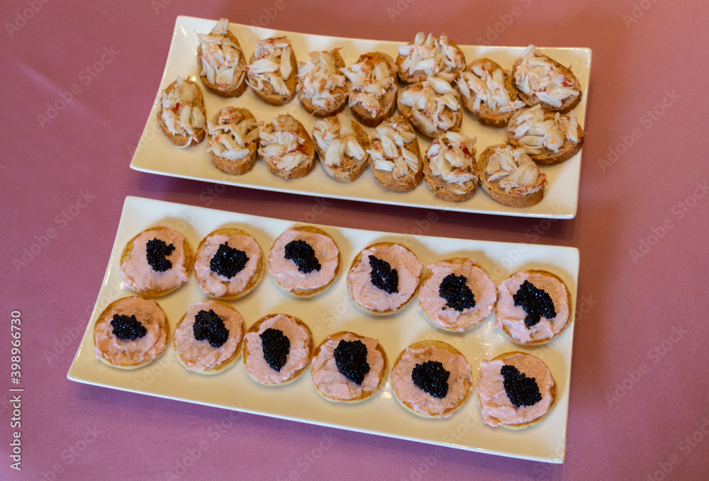 Blinis with taramasalata, lump-fish roe and lobster pieces on white ...