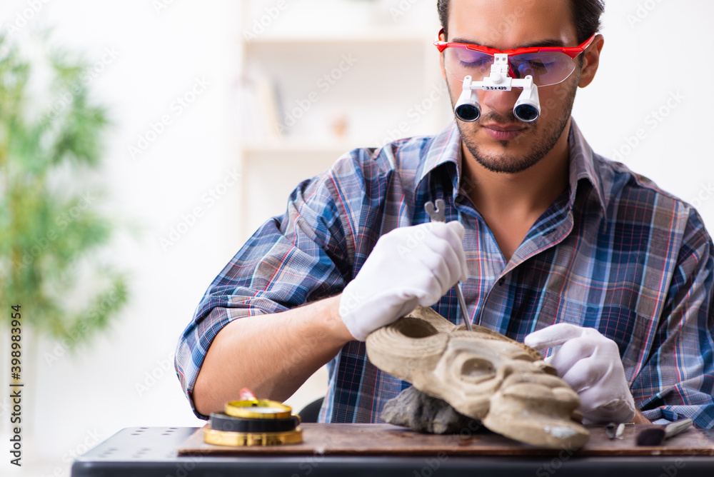 Young male archaeologist studying ancient african stonemask Stock Photo ...