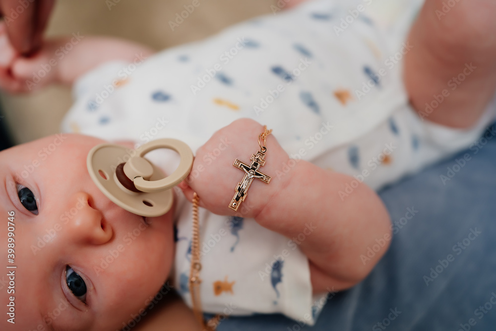 baby with a golden cross on a chain in his hand. Christian faith. Stock ...