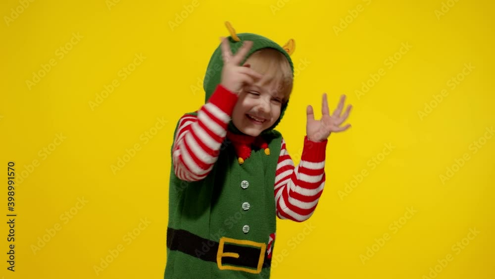 Scared blonde kid teen girl in Christmas elf Santa helper costume ...