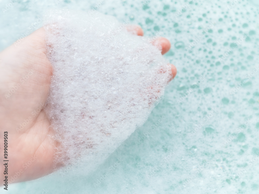 Hand with white foam soap bubbles. Bath time.Handwashing and hygiene ...