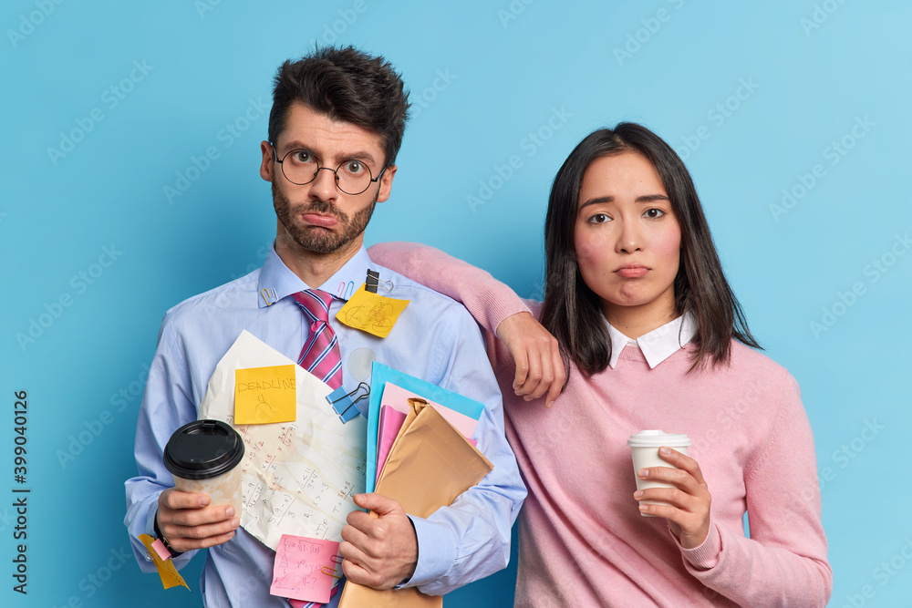 Team work concept. Two displeased tired colleagues prepared financial ...