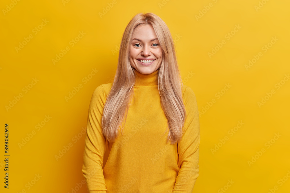 Positive pleasant looking Caucasian female smiles with dimples has long ...