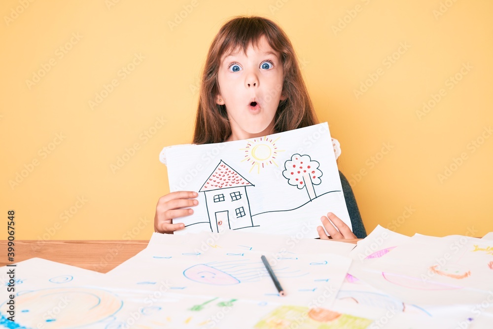 Little caucasian kid girl with long hair drawing colorful paintings ...