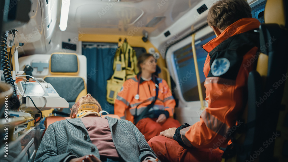Female and Male Professional EMS Paramedics Ride in the Ambulance with ...