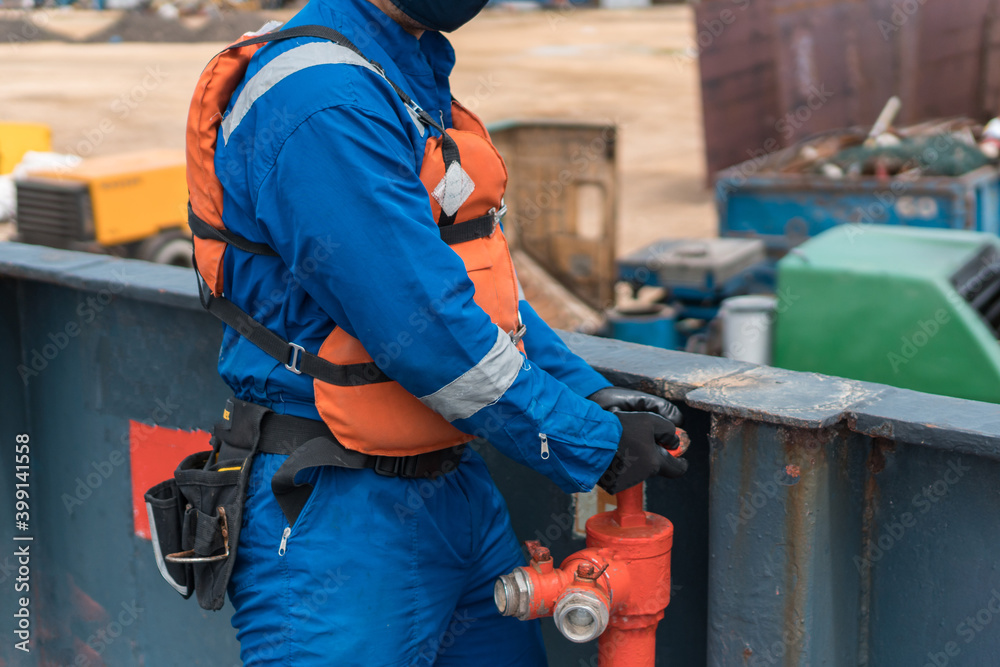 Marine deck officer or chief officer on ship's deck performing work ...