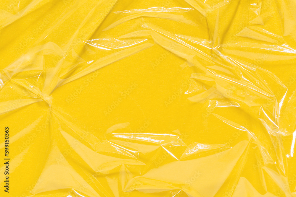 Wrinkled cling film, plastic texture, vinyl background. Yellow overlay ...
