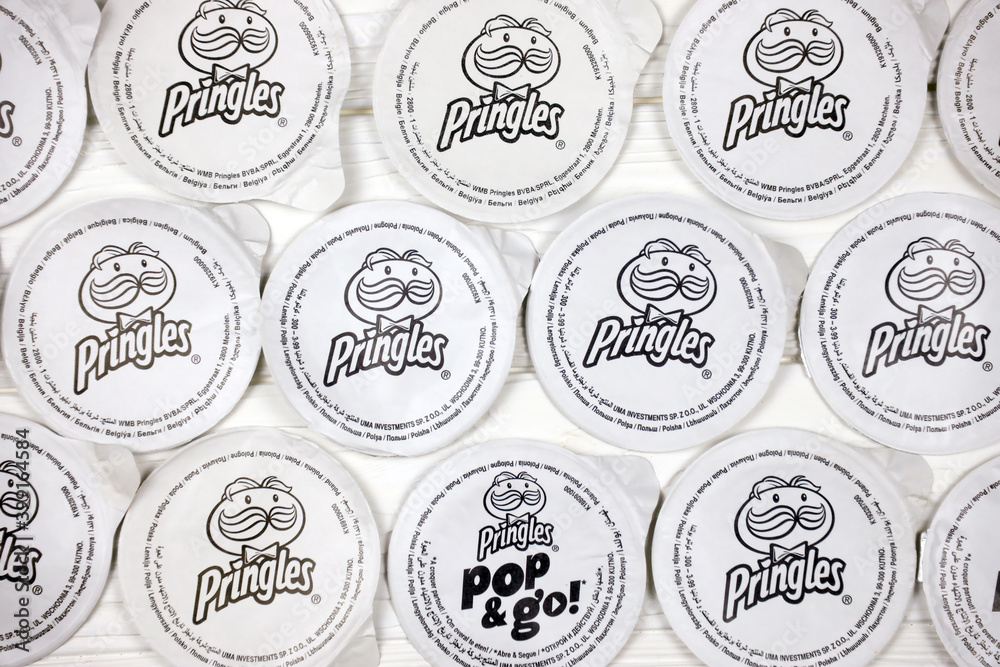Pringles logo on paper membranes on white wooden table. Pringles is a ...