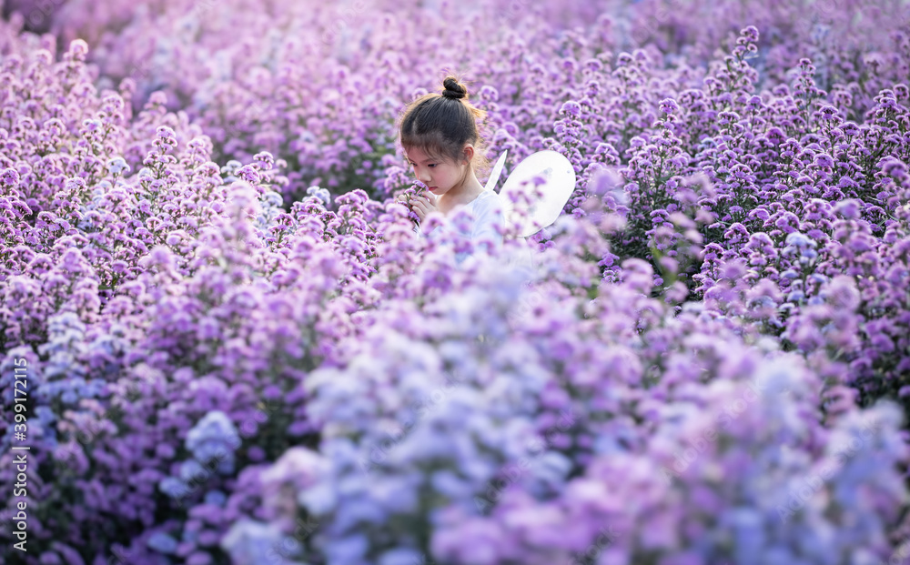 Cute little girl smelling flowers and wear a magic ballet fairy costume ...