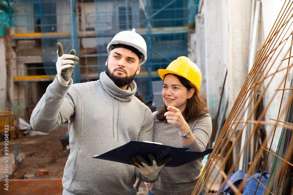 Civil engineers inspecting process of building overhaul, comparing to ...
