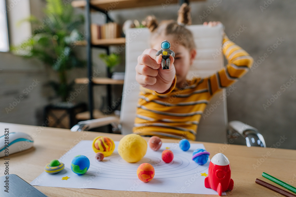 Girl sculpts planets models from kids clay Stock Photo | Adobe Stock
