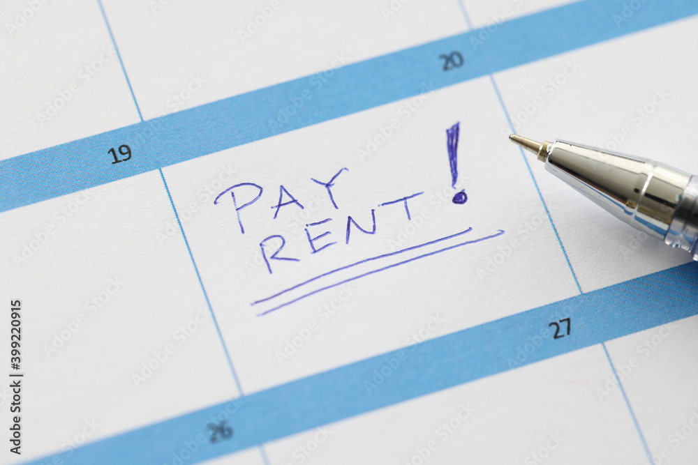 Pay rent is written on sheet of calendar with ballpoint pen closeup ...