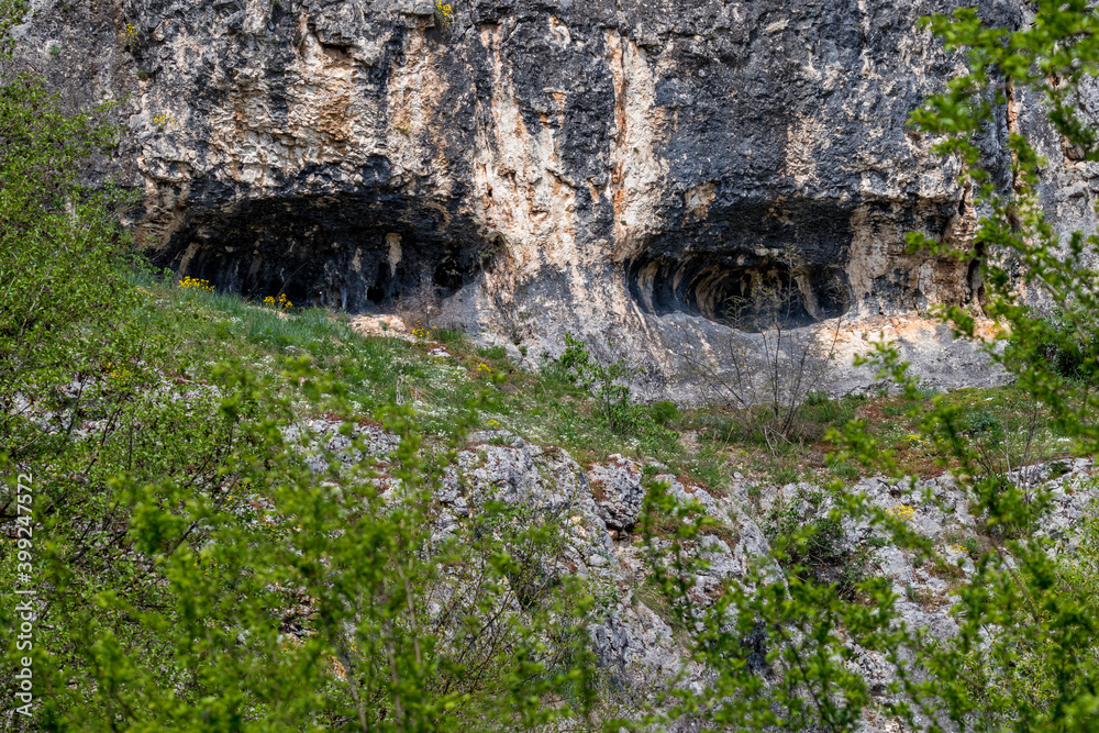 Karst caves front view, having the shape of two huge black eyes near ...