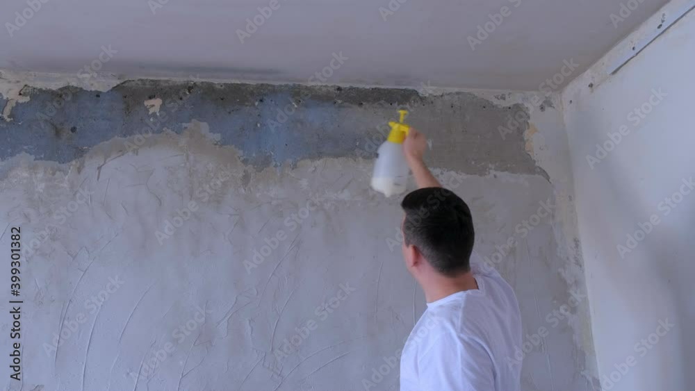 Man worker spraying primer to wall prepare it to plaster, renovation ...