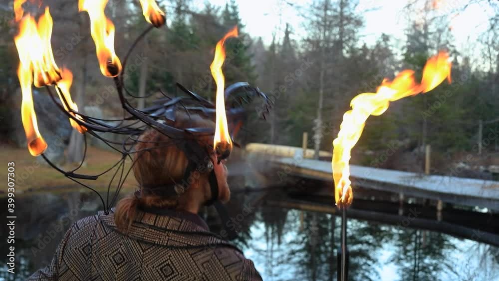 Handsome young male performer wearing dragon helmet and holding fire ...