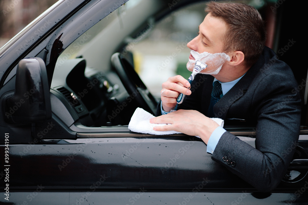 Businessman shaving in car by razor and foam at the wheel. Shaving man ...