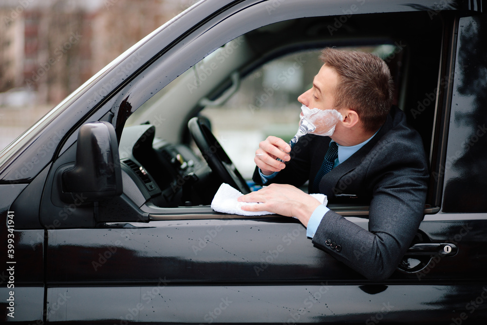 Businessman shaving in car by razor and foam at the wheel. Shaving man ...