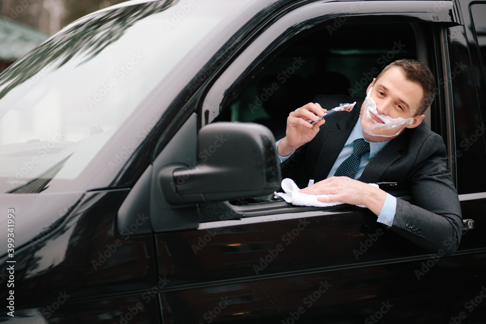 Businessman shaving in car by razor and foam at the wheel. Shaving man ...