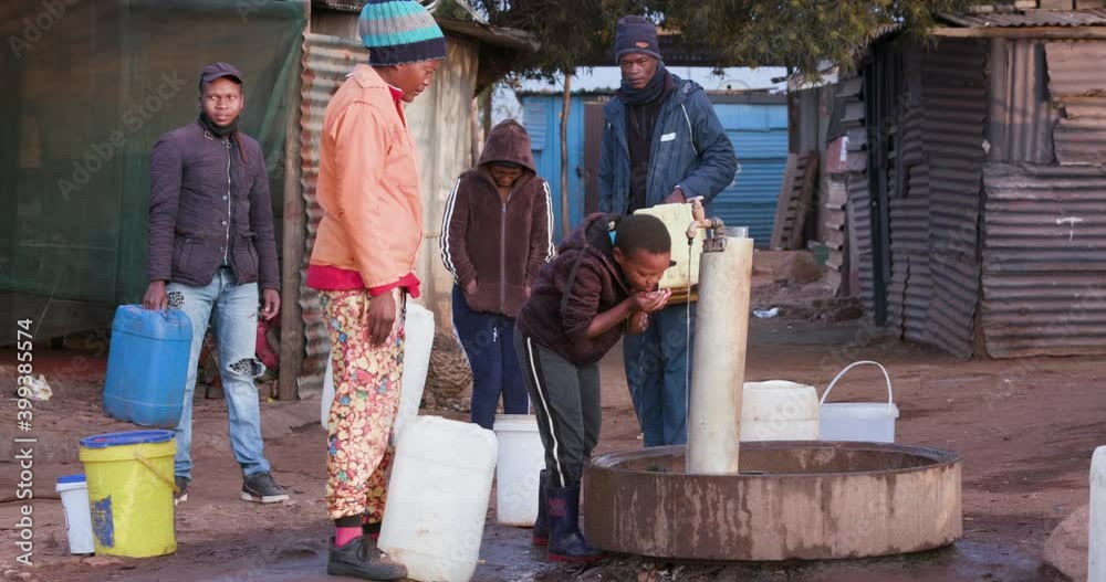 Water crisis. Wide view of a young black african boy drinking water ...