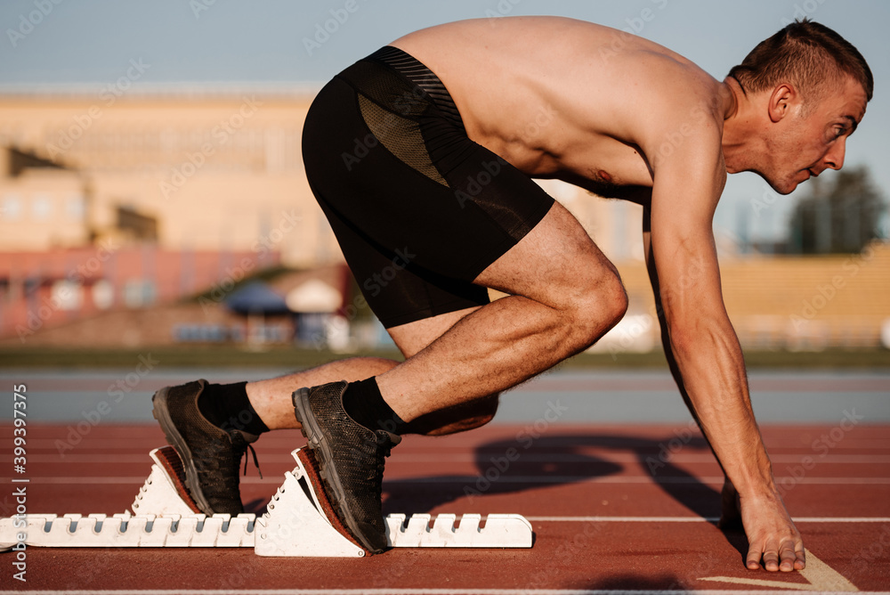 Runner frozen in tense pose bending over and getting ready for start ...