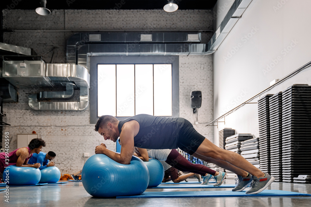 People using exercise balls in a gym. Stock Photo | Adobe Stock