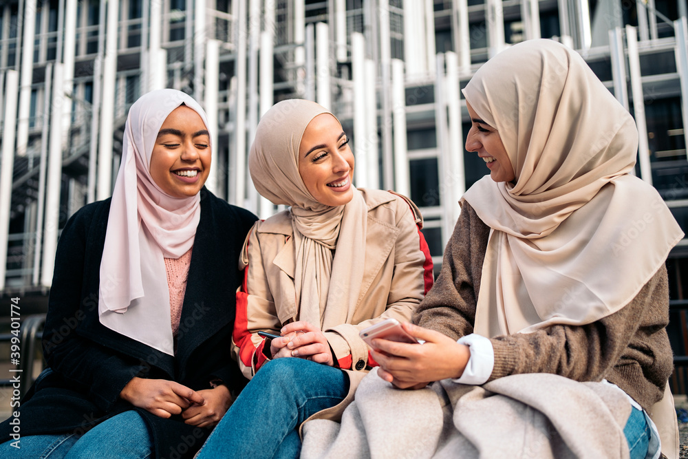 Three muslim women talking and laughing. Stock Photo | Adobe Stock