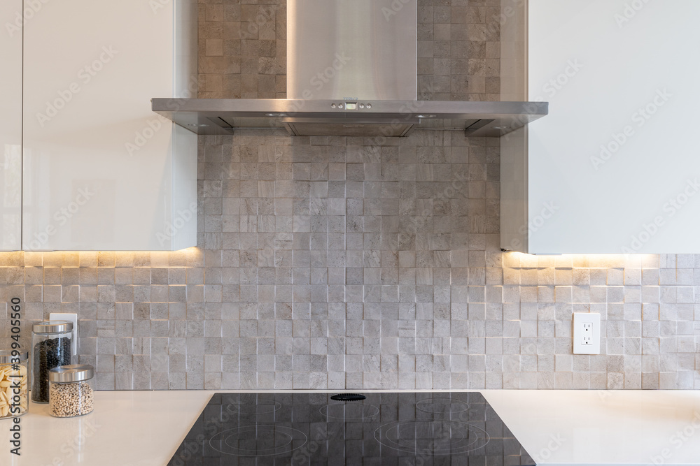 Modern kitchen details of flat stovetop, granite counter and stone ...