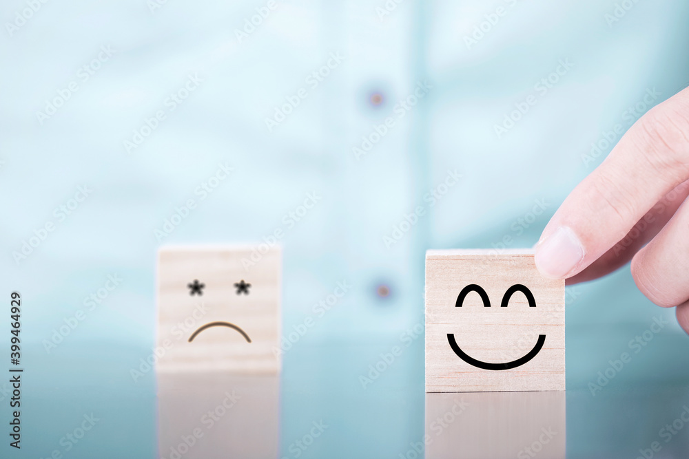 Businessman chooses a smile emoticon icons face happy symbol on wooden ...