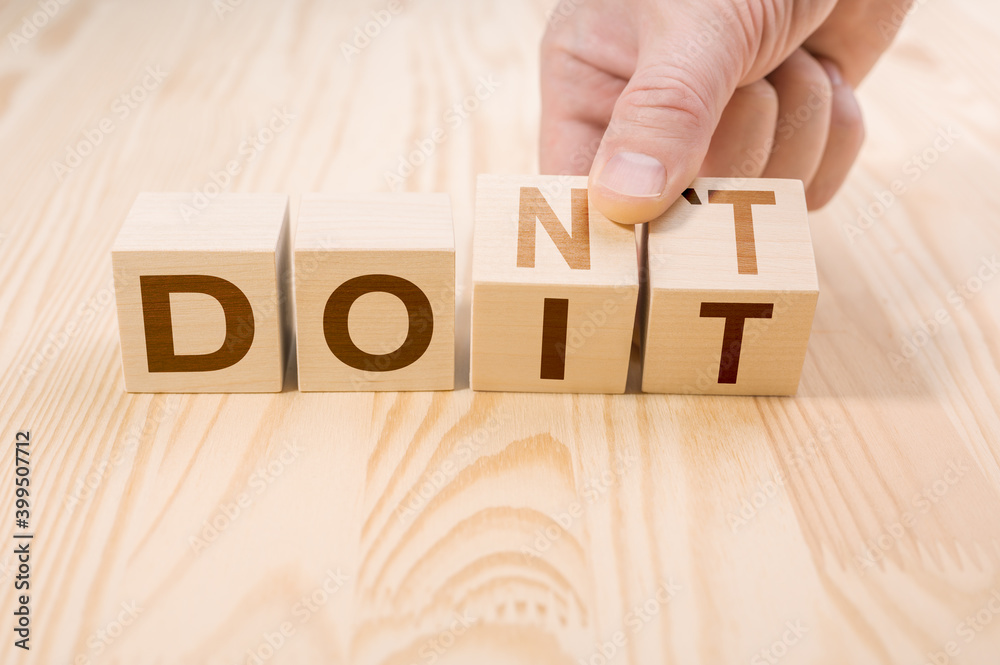 Hand flip wooden cube block with word don t change to do it on wooden ...
